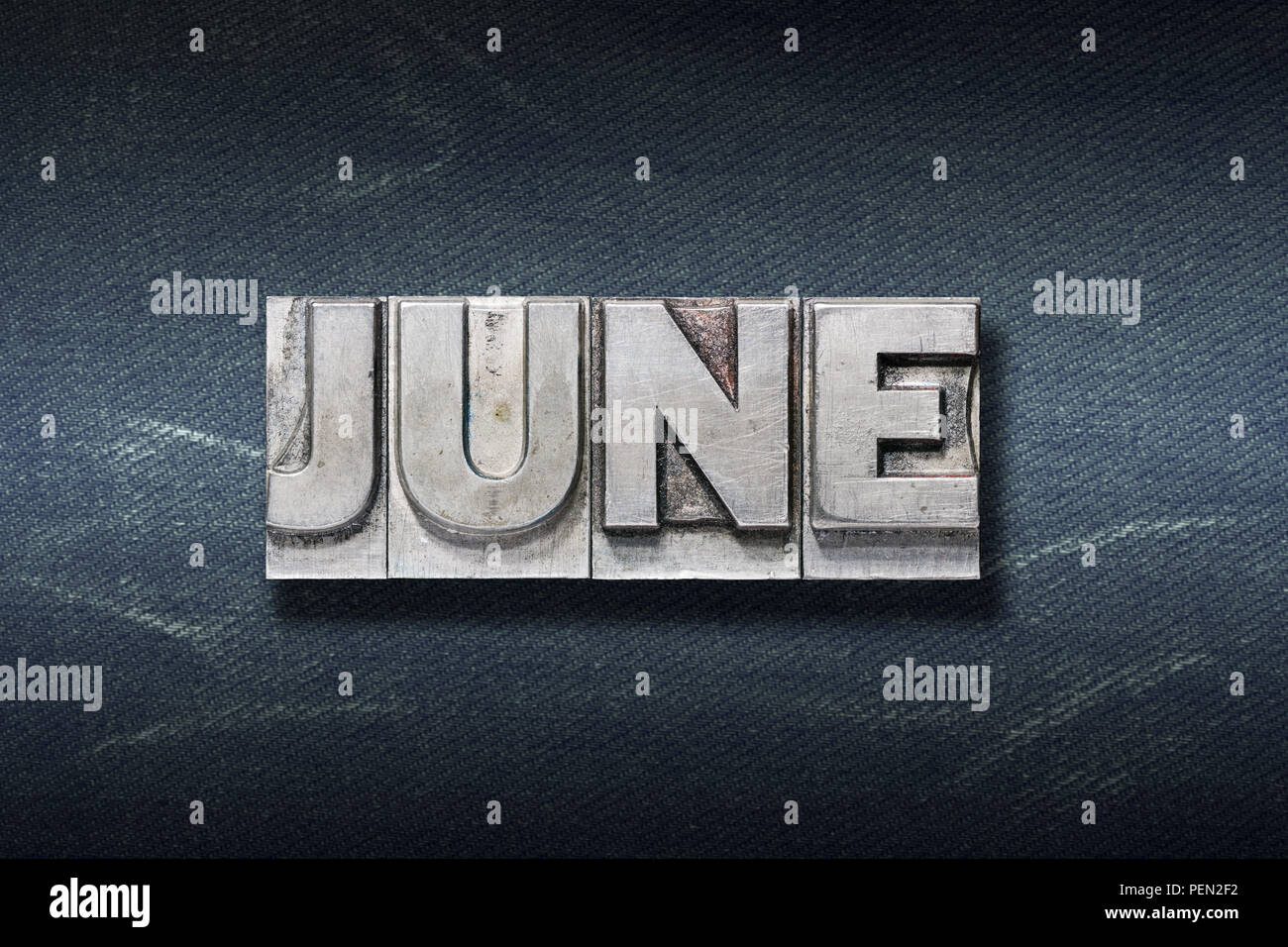 June word made from metallic letterpress on dark jeans background Stock ...