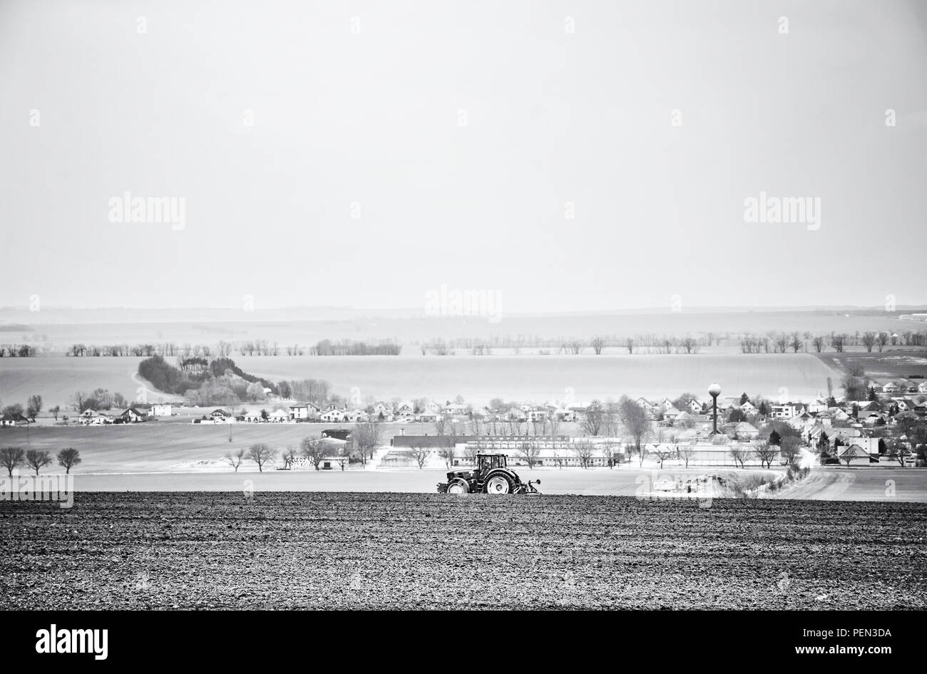 Tractor plowing on the wheat field. Agricultural scene. Black and white ...
