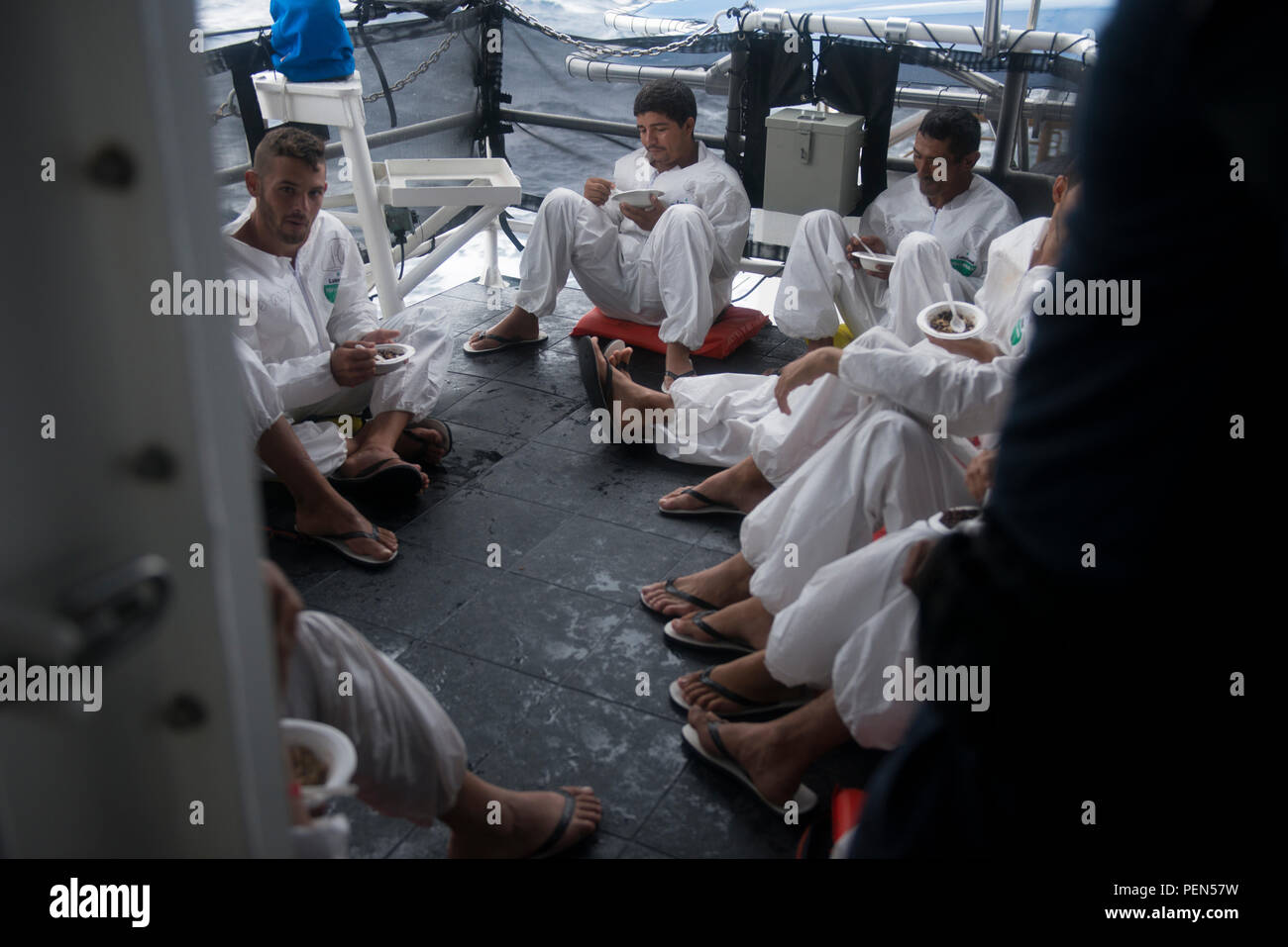 Cuban nationals aboard the Coast Guard Cutter Kathleen Moore eat rice ...