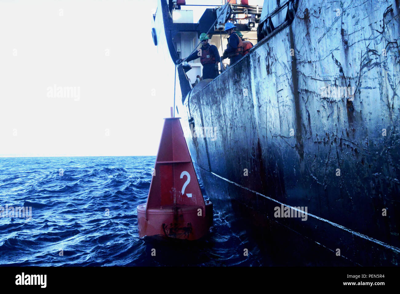 Crew members aboard USCGC Walnut prepare a buoy to be taken in tow by a ...