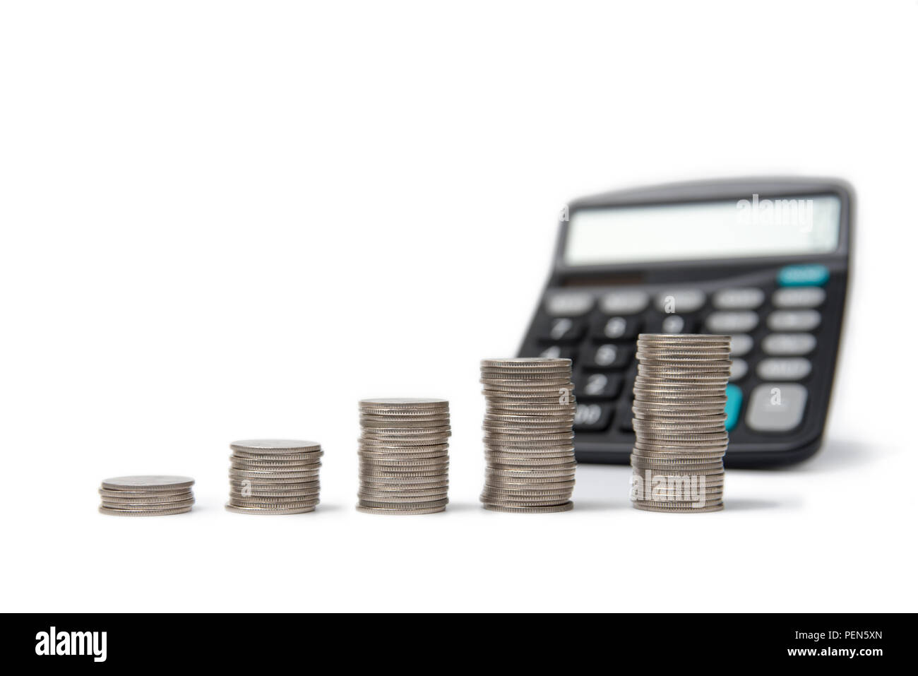 Coin stacks and calculator on a white background Stock Photo - Alamy