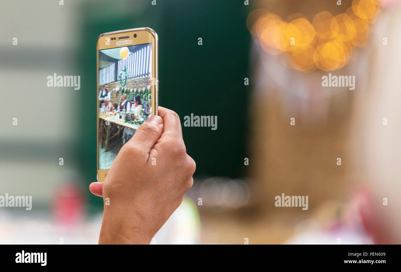 Image of Hand Holding Smartphone Filming Wedding Top Table with Guest ...