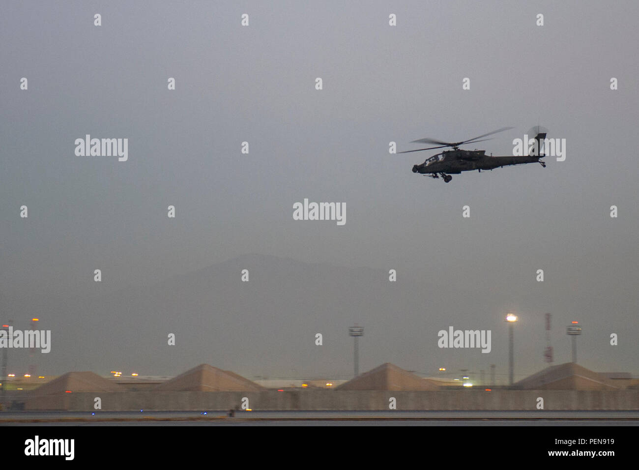 An AH-64 Apache helicopter flies over the flightline at Bagram Air ...