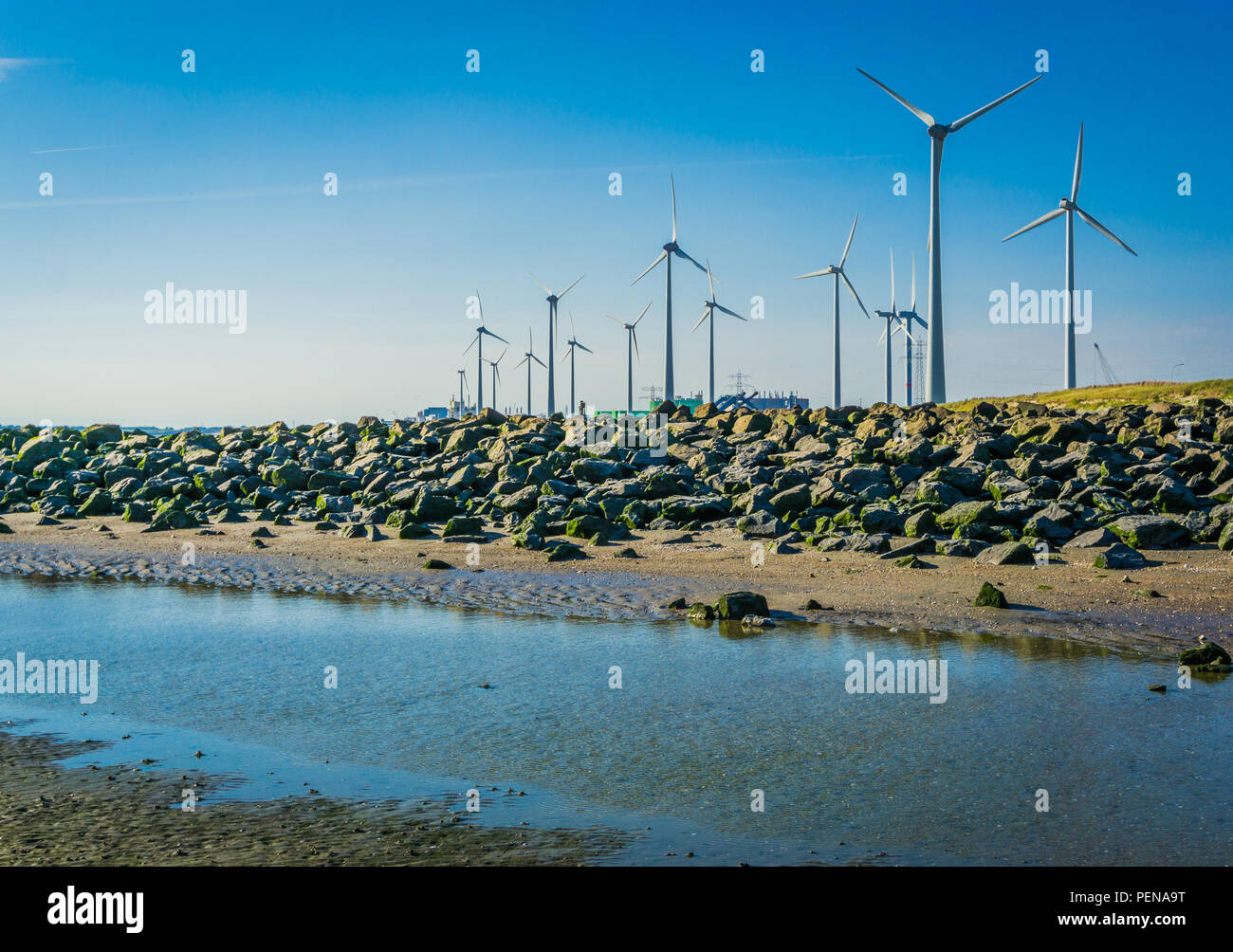 wind mill park with rocks and water on the beach distance view Stock ...