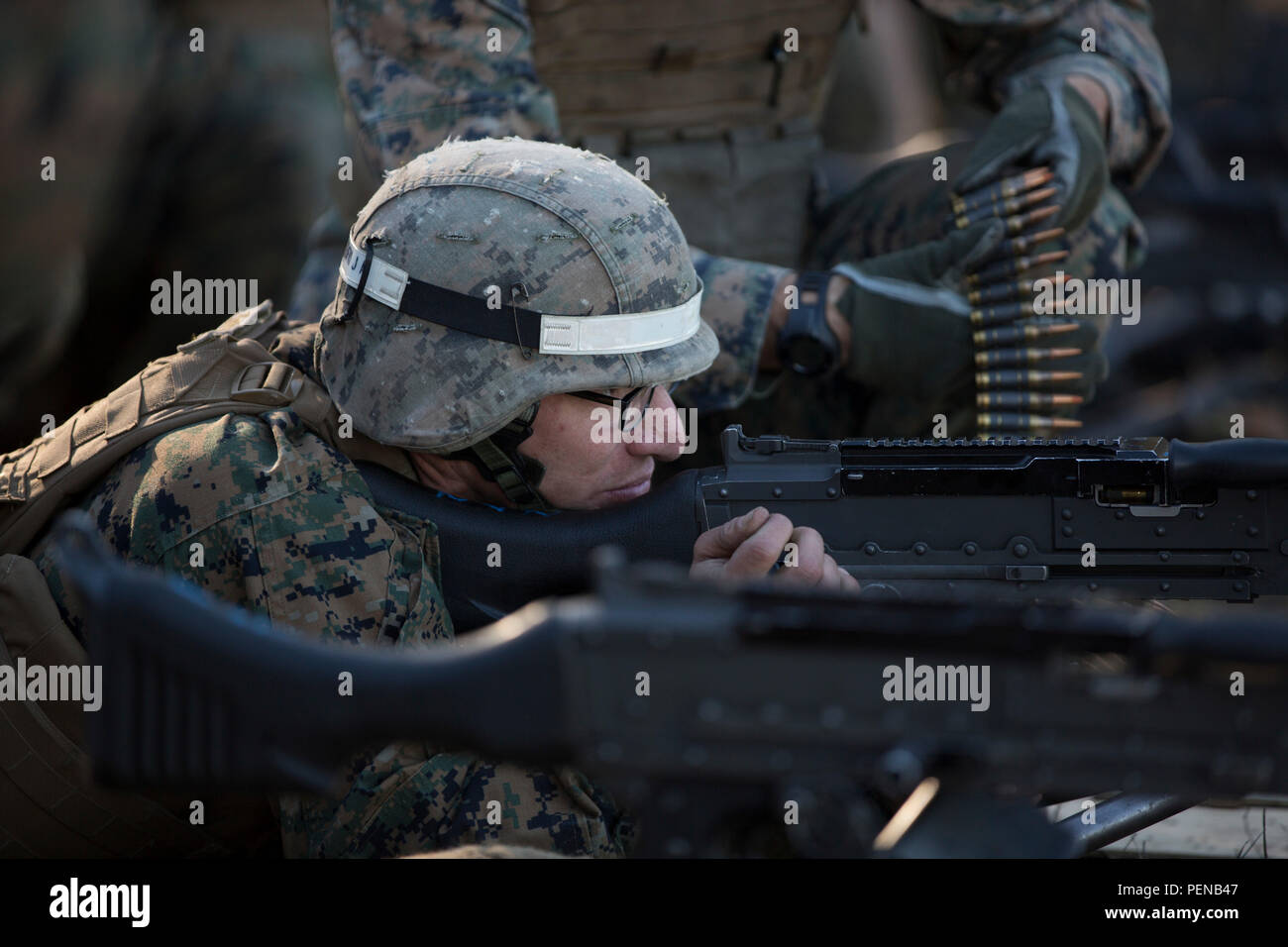 A combat instructor fires the M-240B medium machine gun while ...