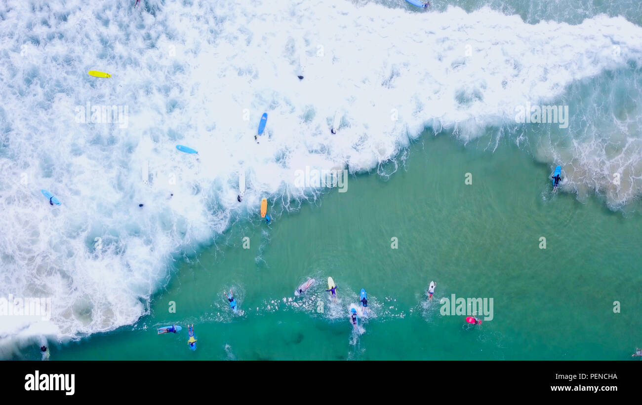 Surfers catching waves in the Mediterranean Sea - Top down aerial view ...