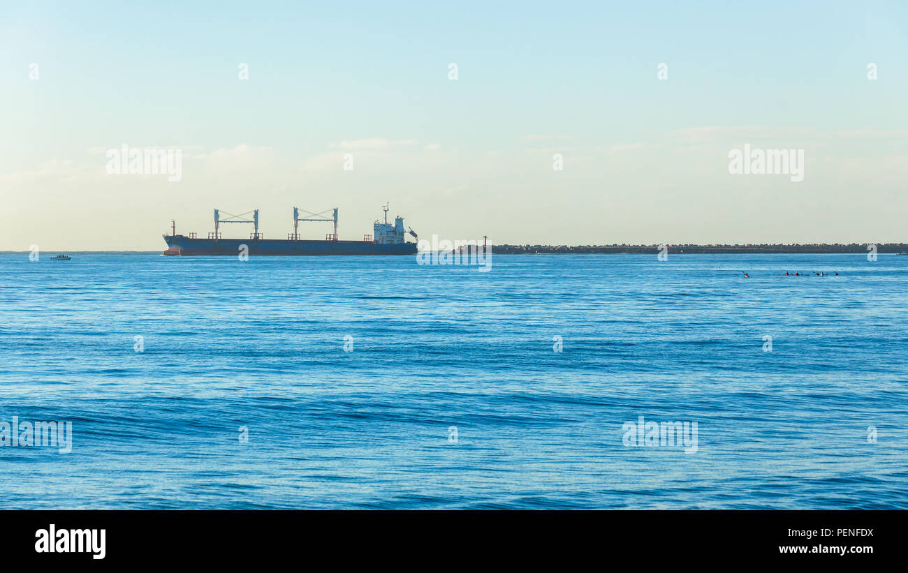 Ship departs harbor port piers onto ocean seas landscape Stock Photo ...