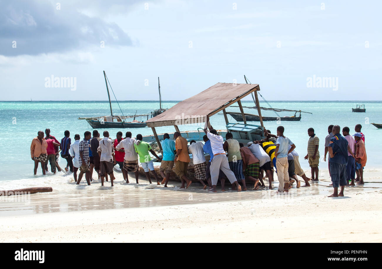 Stone Town, Zanzibar, 24 May - 2015: Men pushing fishing boat into the ...