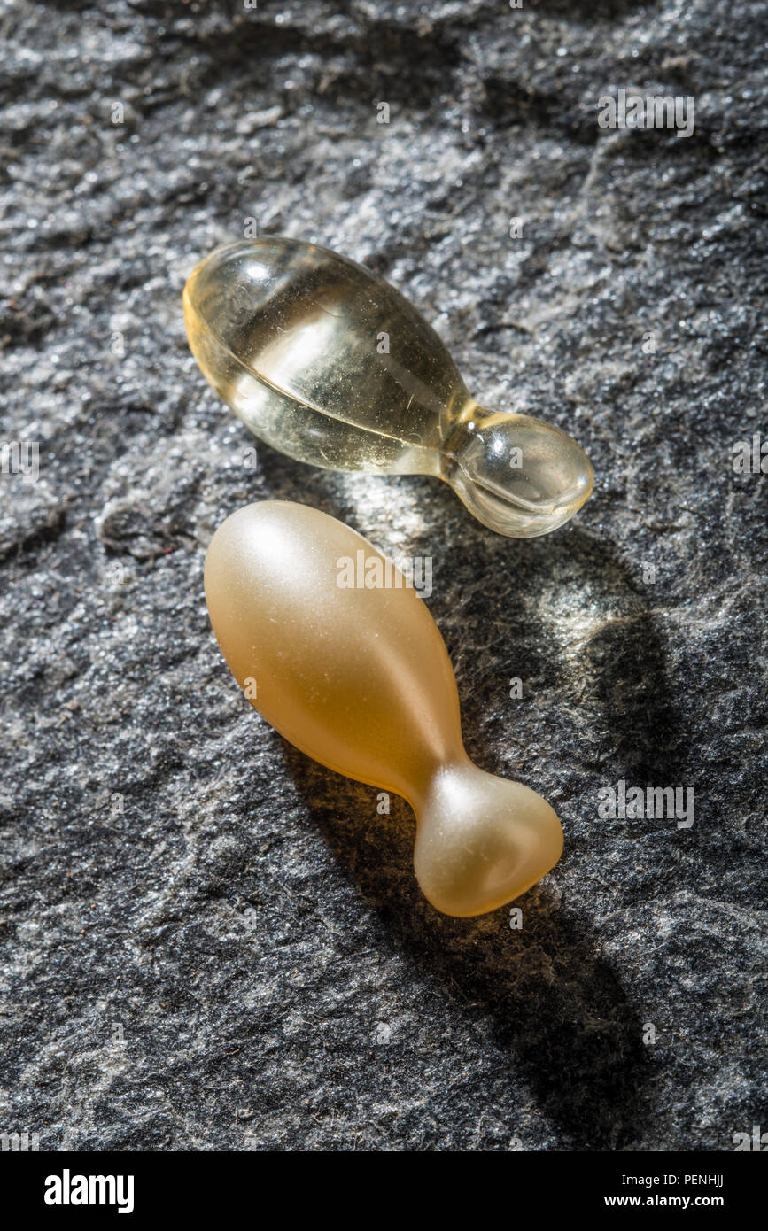 Gel capsules on a stone background Stock Photo - Alamy
