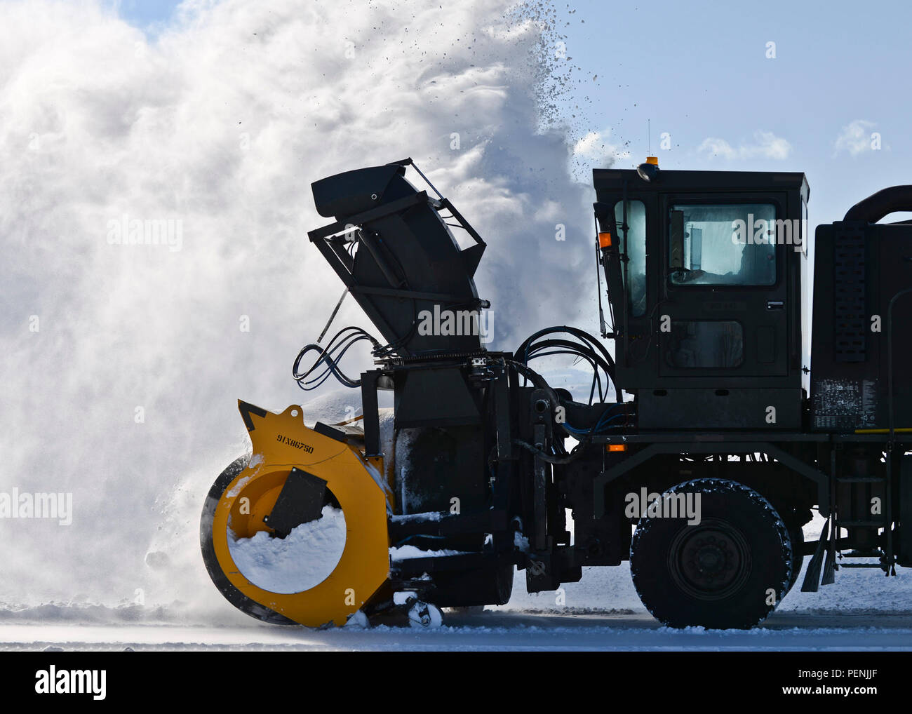 A member of the 28th Civil Engineering Squadron operates a snow blower ...