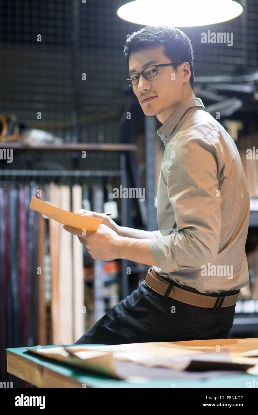 Confident leather craftsman drawing sketch in studio Stock Photo - Alamy