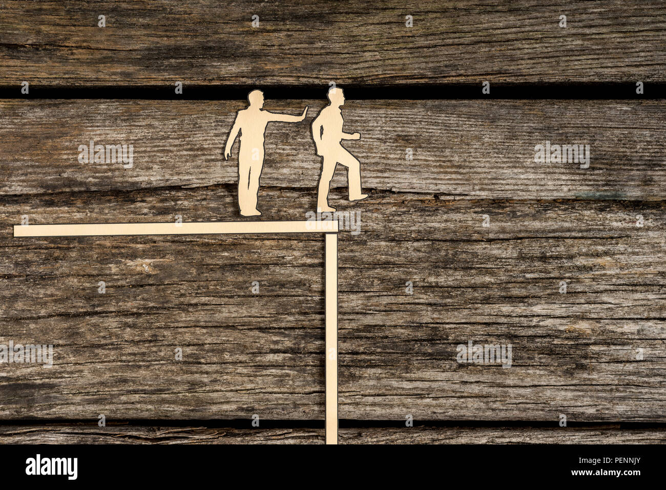 Small silhouette cutout men standing next to each other as one pushes ...