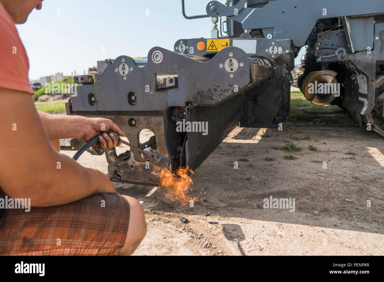 The man uses a fire from a gas cylinder in order to melt old dried ...