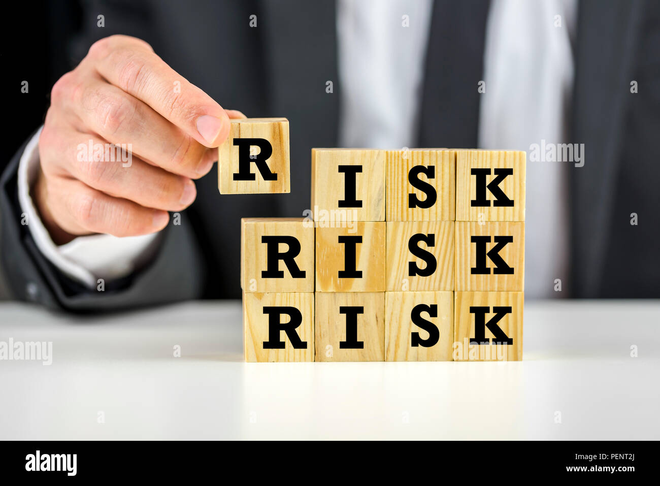 Man stacking wooden letter blocks that spell the word Risk Stock Photo ...