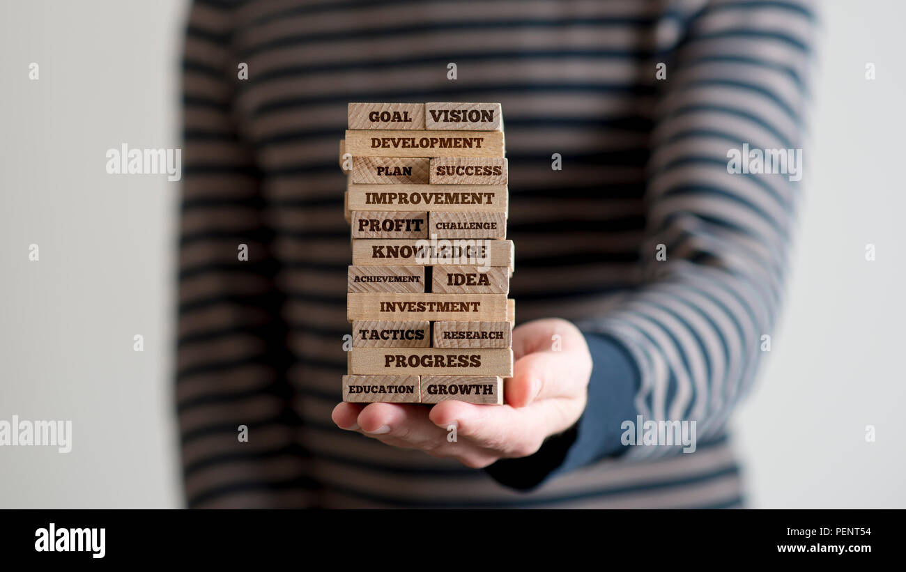 Close-up stretched hand holding stack of wooden bricks with ...