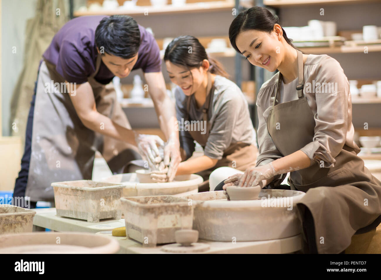 Potter teaching young women making pottery Stock Photo - Alamy
