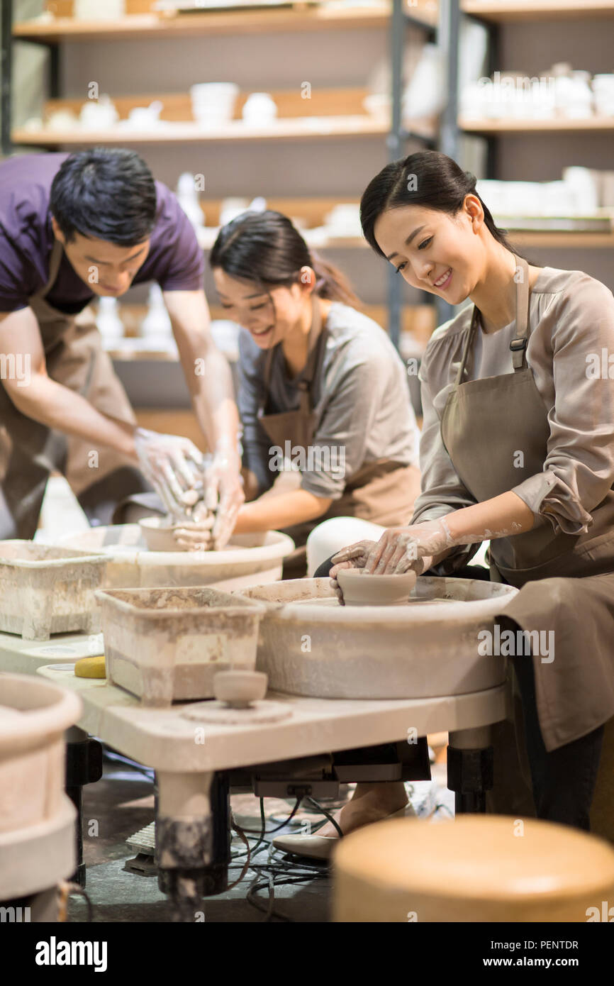 Potter teaching young women making pottery Stock Photo - Alamy