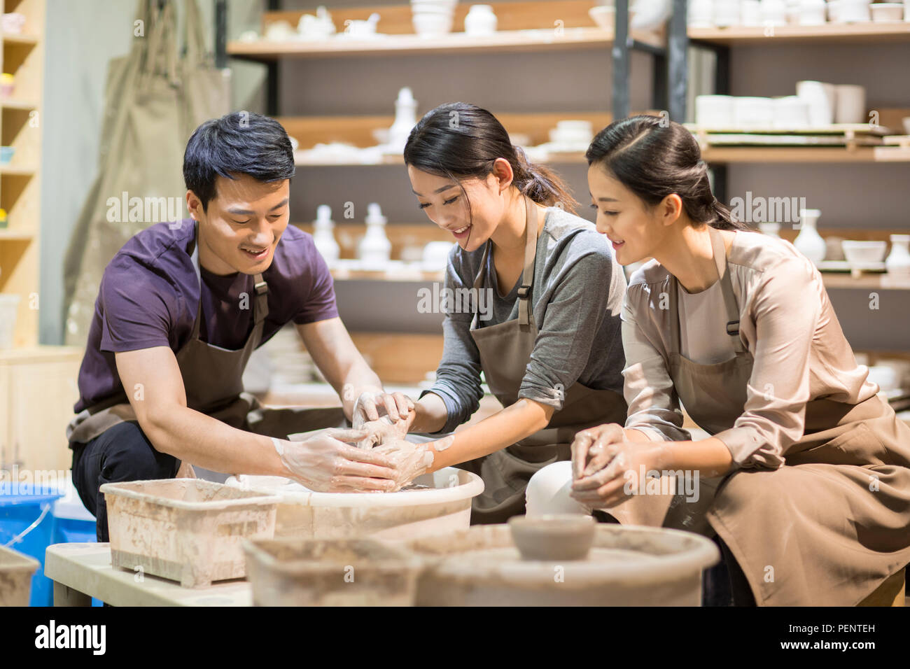 Potter teaching young women making pottery Stock Photo - Alamy