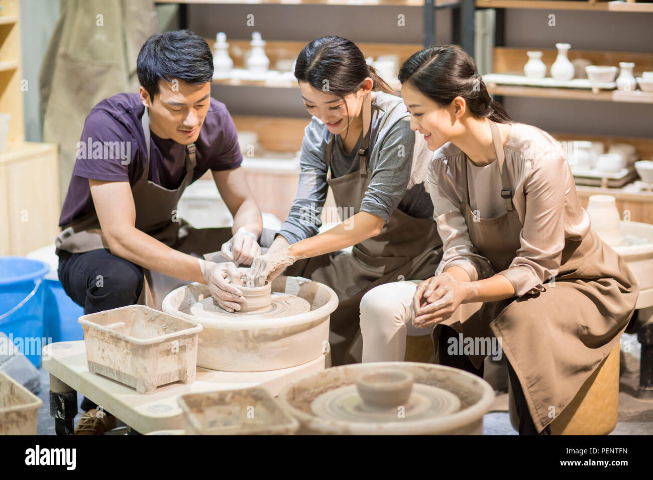Potter teaching young women making pottery Stock Photo - Alamy