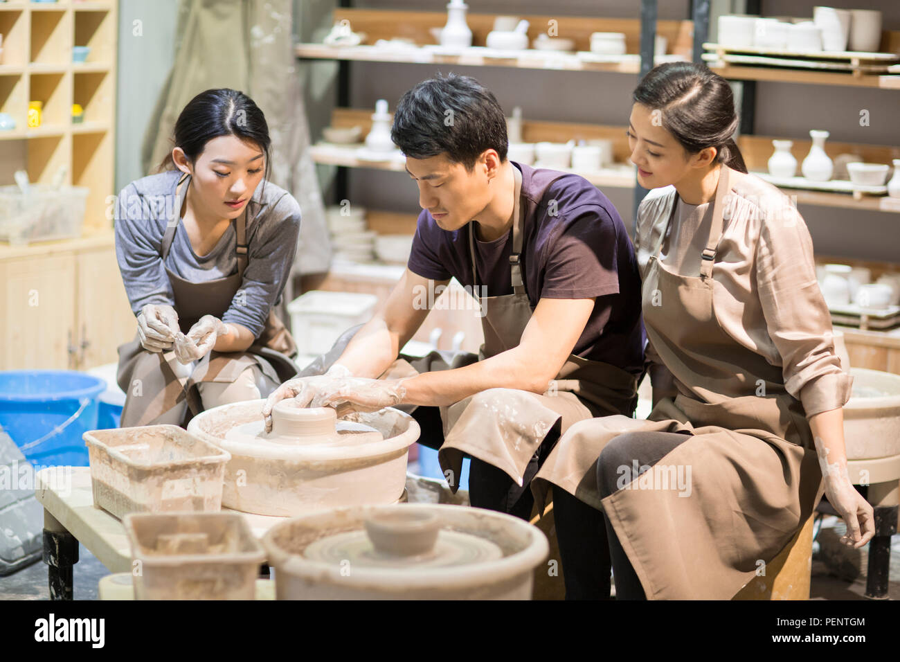 Potter teaching young women making pottery Stock Photo - Alamy