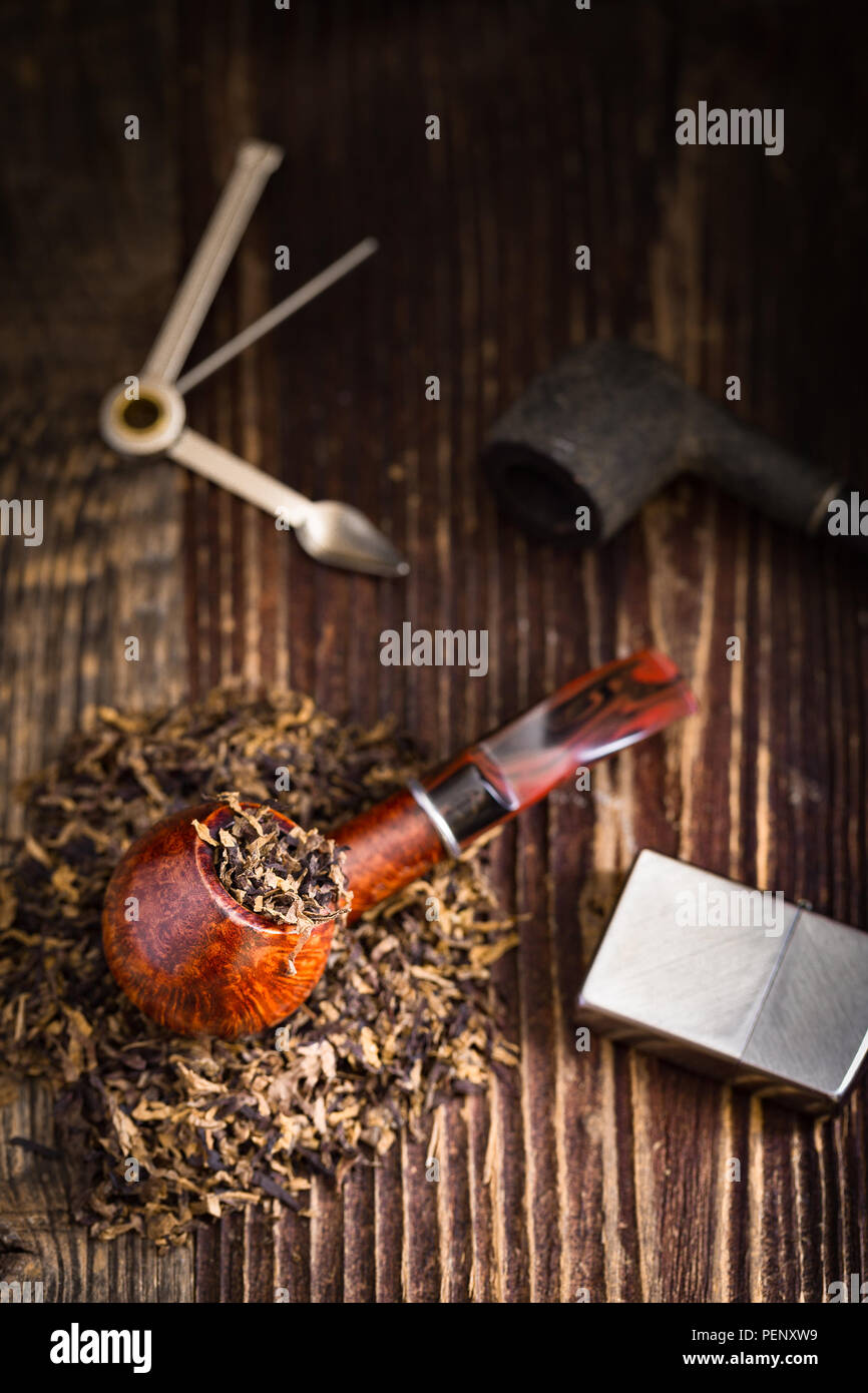 Smoking pipe with tobacco leaves on a rustic wooden table Stock Photo ...