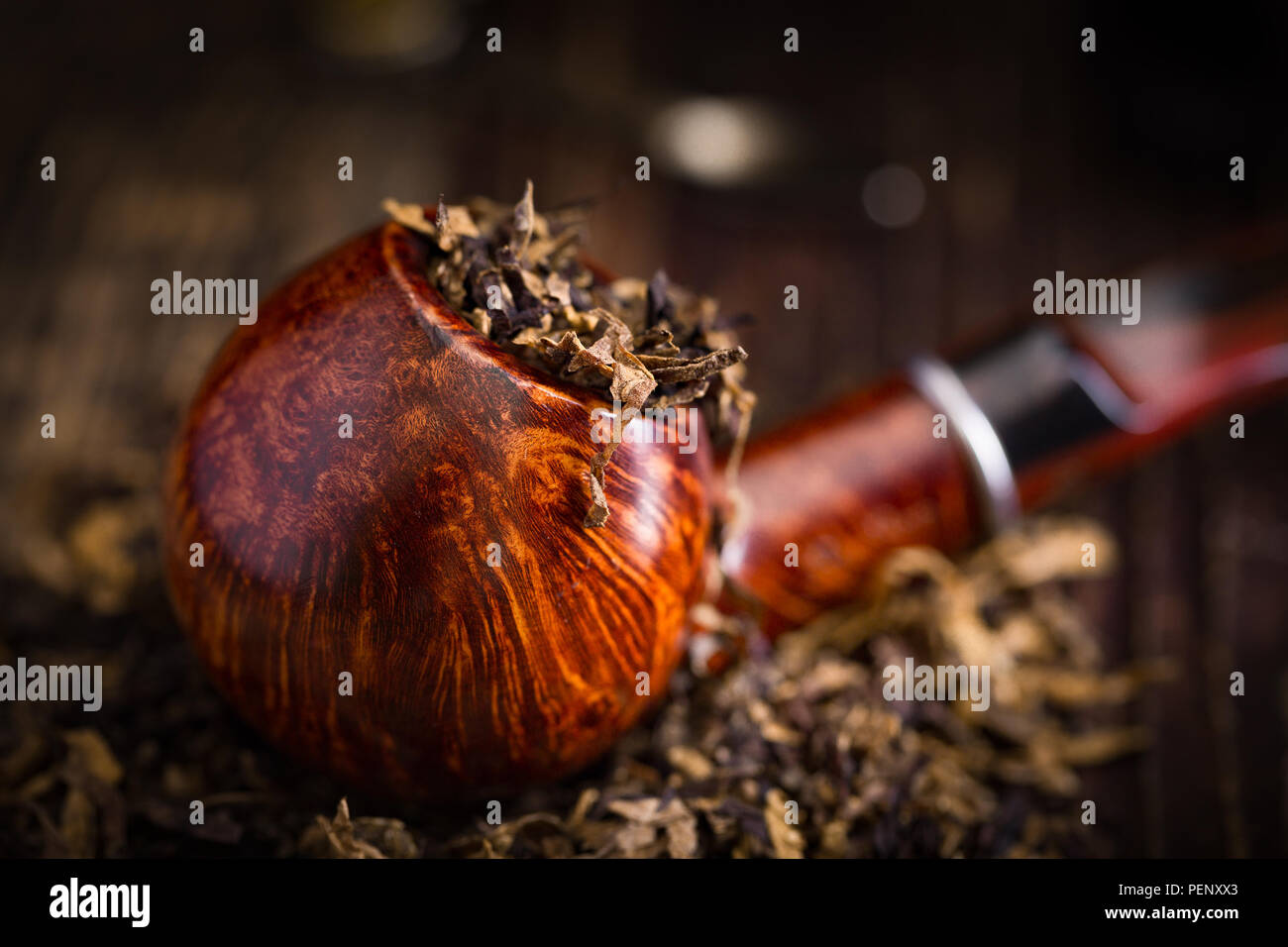 Smoking pipe with tobacco leaves on a rustic wooden table Stock Photo ...