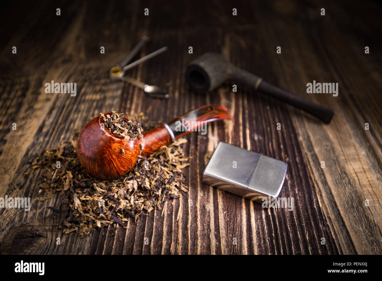 Smoking pipe with tobacco leaves on a rustic wooden table Stock Photo ...