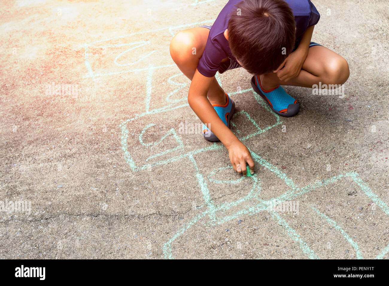 Child playing hopscotch game on concrete floor outdoors in summer Stock ...