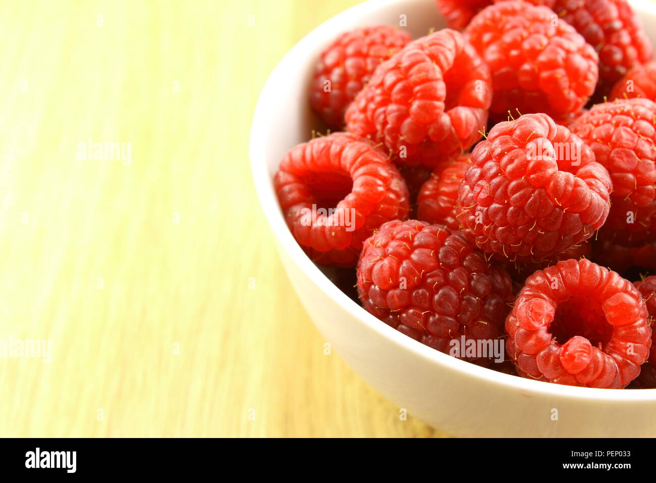 fresh red raspberry fruits in a small white bowl Stock Photo - Alamy