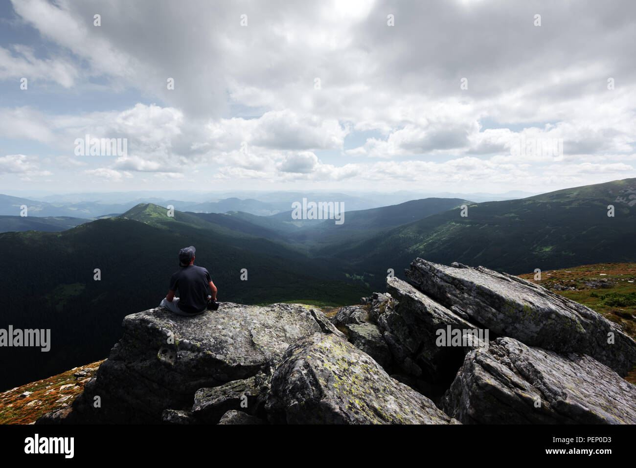 Young man sitting by cliff edge hi-res stock photography and images - Alamy