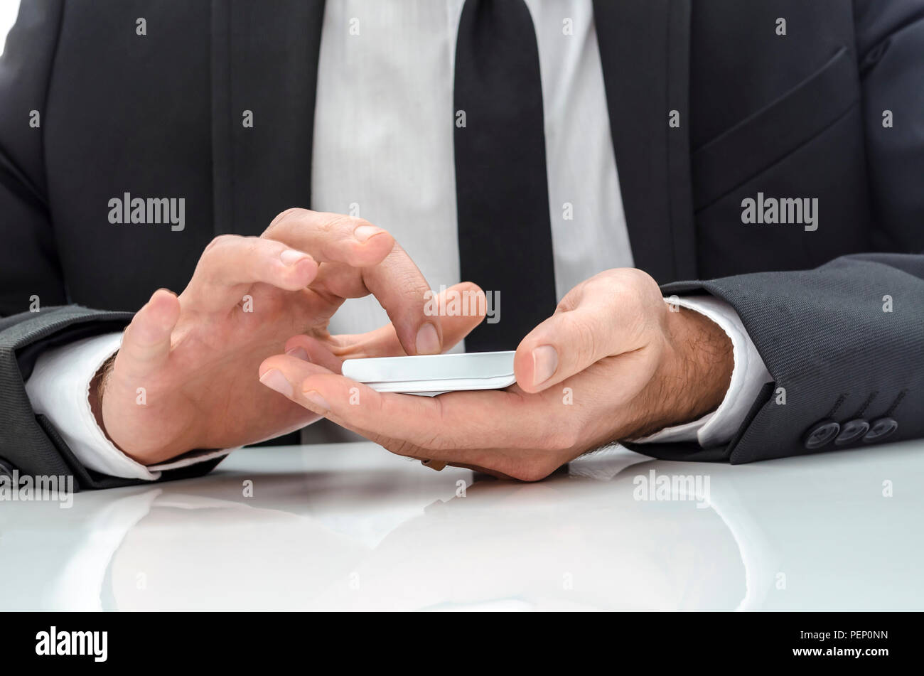 Businessman using a mobile phone on an office desk Stock Photo - Alamy