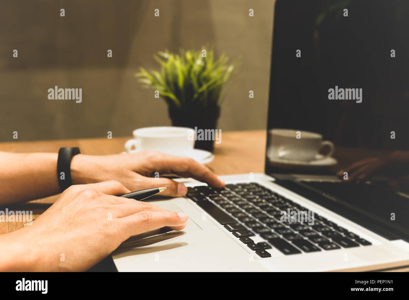 Man hand holding pen using keyboard of lap top in color matte Stock ...