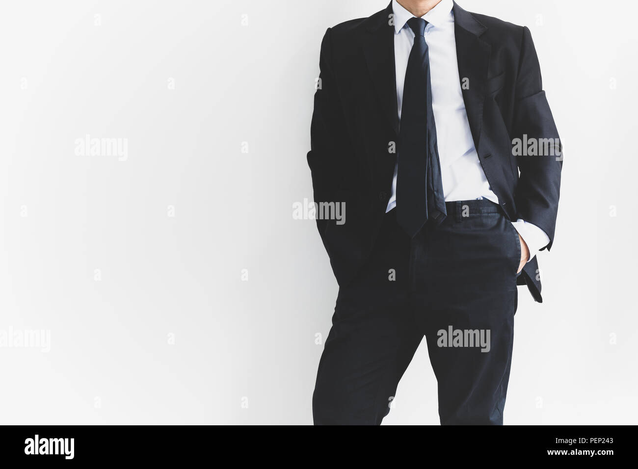 Businessman relax standing with hand in pocket on front of white ...