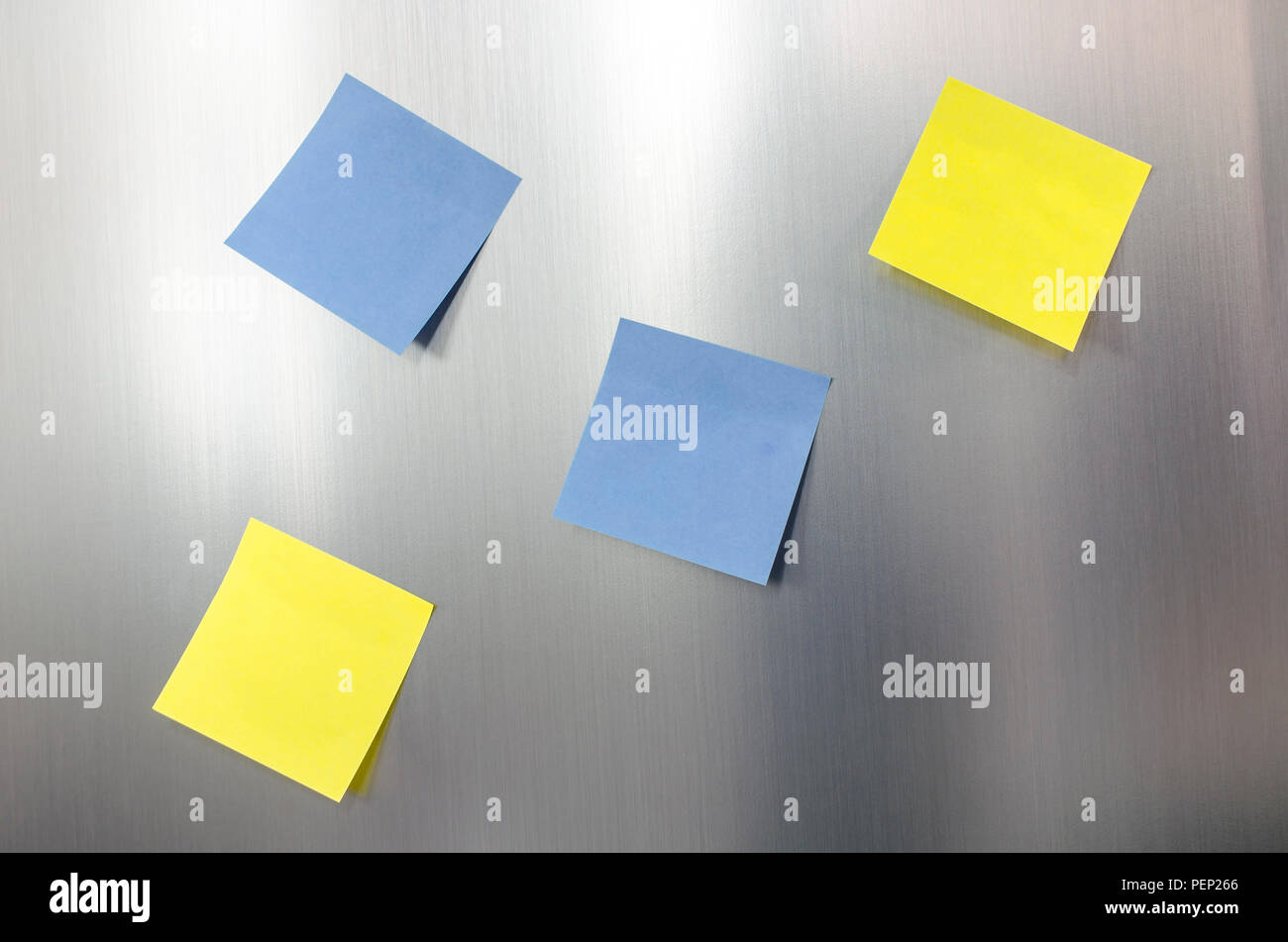 Four blank sticky note reminders on a stainless fridge Stock Photo - Alamy