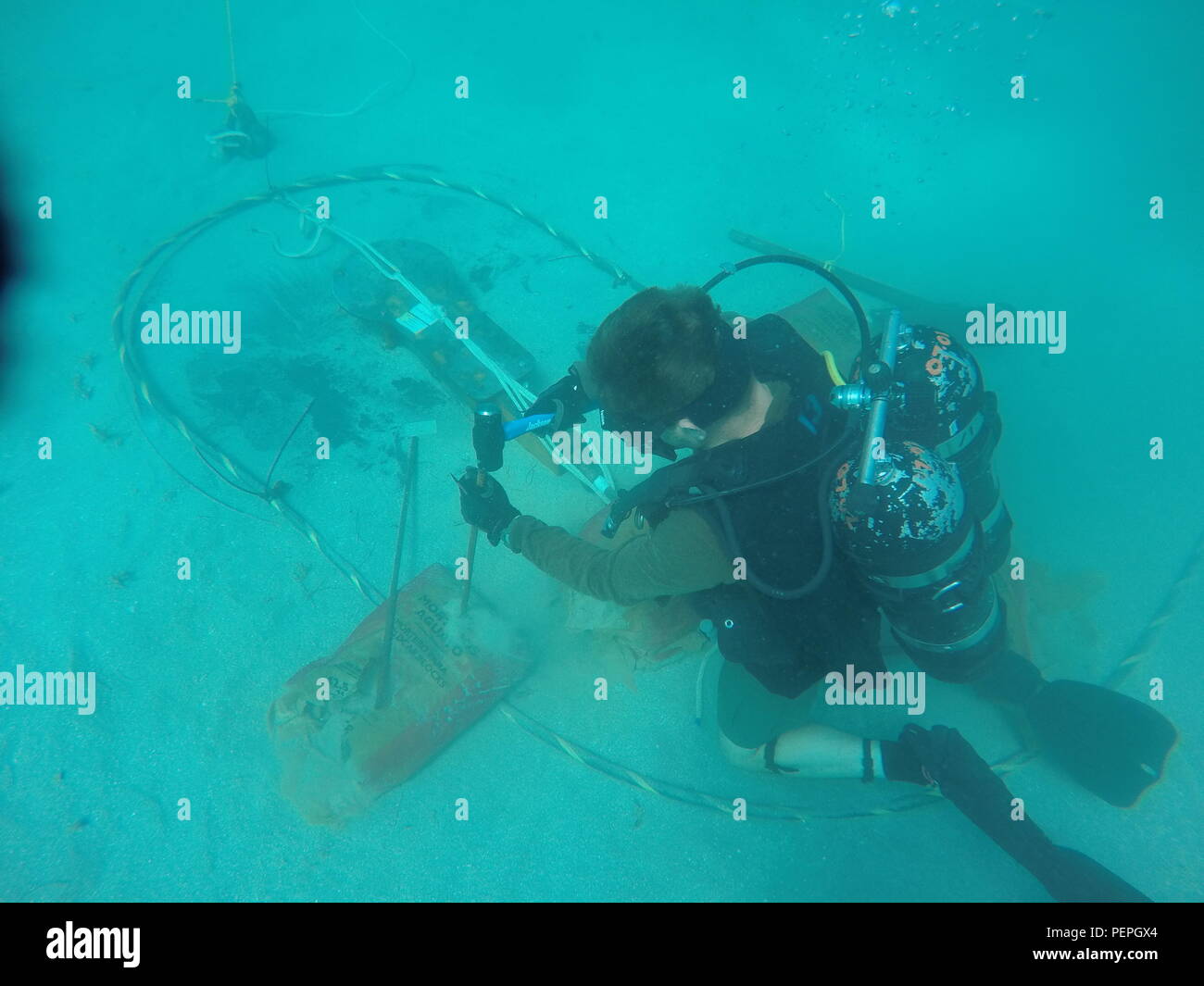 BU1 Christopher Kelly of Underwater Construction Team ONE secures the ...