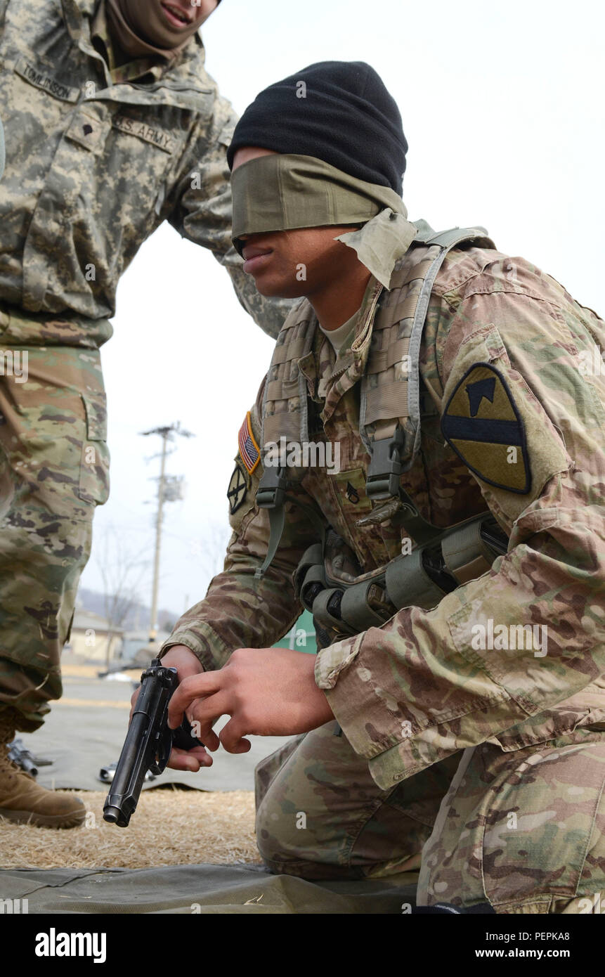 One Soldier guides another through disassembling an M9 pistol while ...