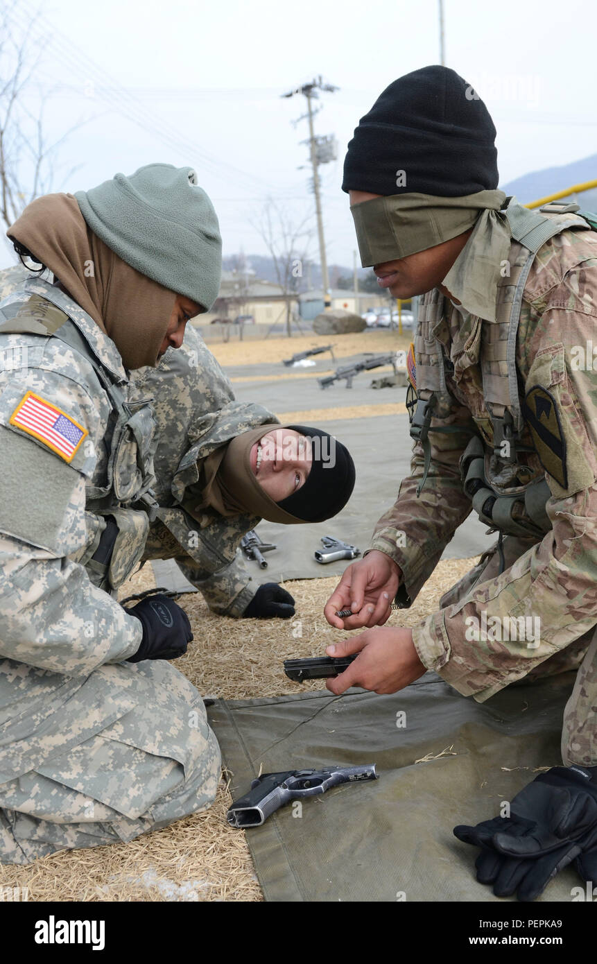 One Soldier guides another through disassembling an M9 pistol while ...