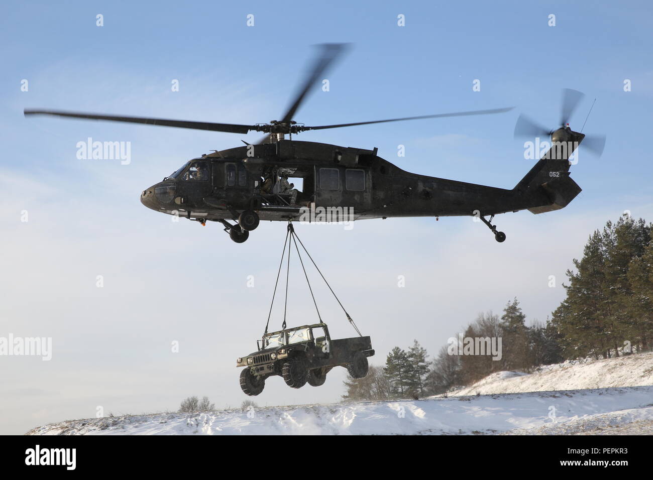 A UH-60 Black Hawk helicopter transports a Humvee while conducting ...
