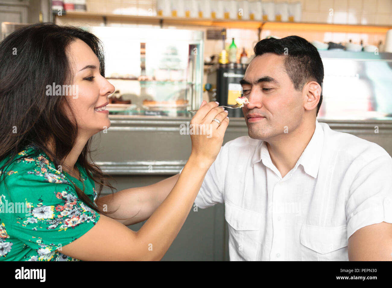 Young man gives a piece of cake to his wife Stock Photo - Alamy