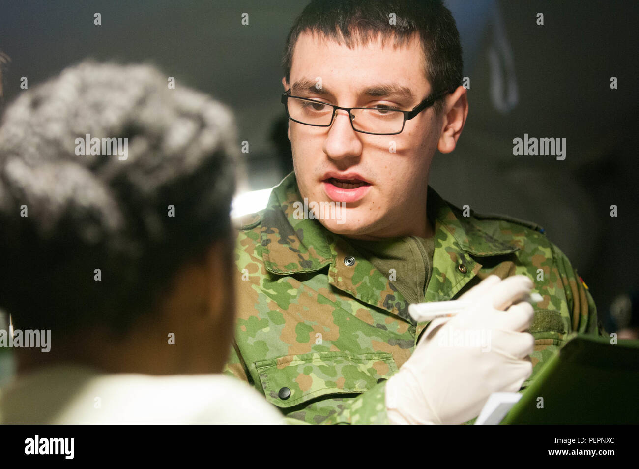 A Bundeswehr medical provider at the Role 1 assesses Pfc. Katia Blake ...