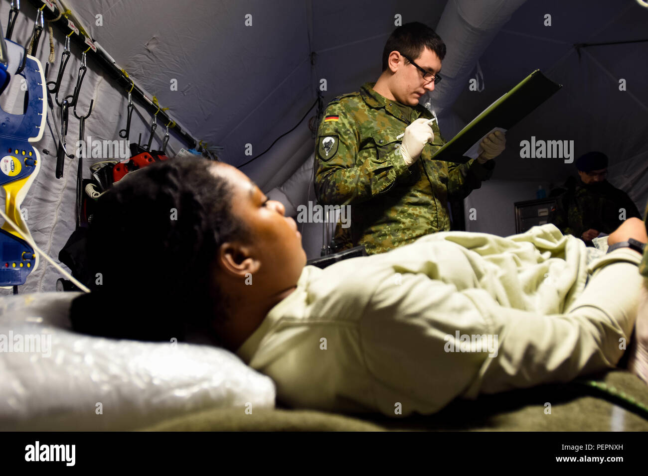 A Bundeswehr medical provider at the Role 1 assesses Pfc. Katia Blake ...