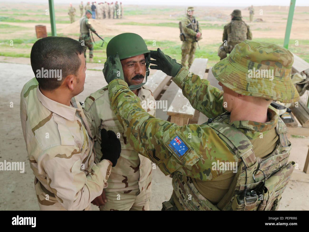 An Australian soldier with Task Group Taji, helps an Iraqi soldier with ...