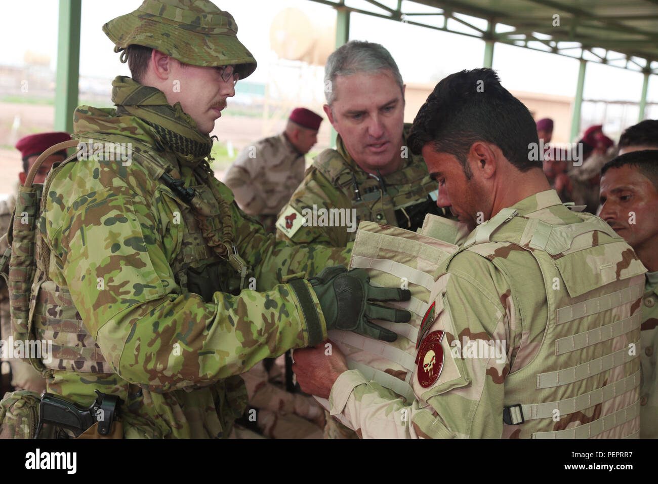 An Australian soldier with Task Group Taji, helps an Iraqi soldier with ...