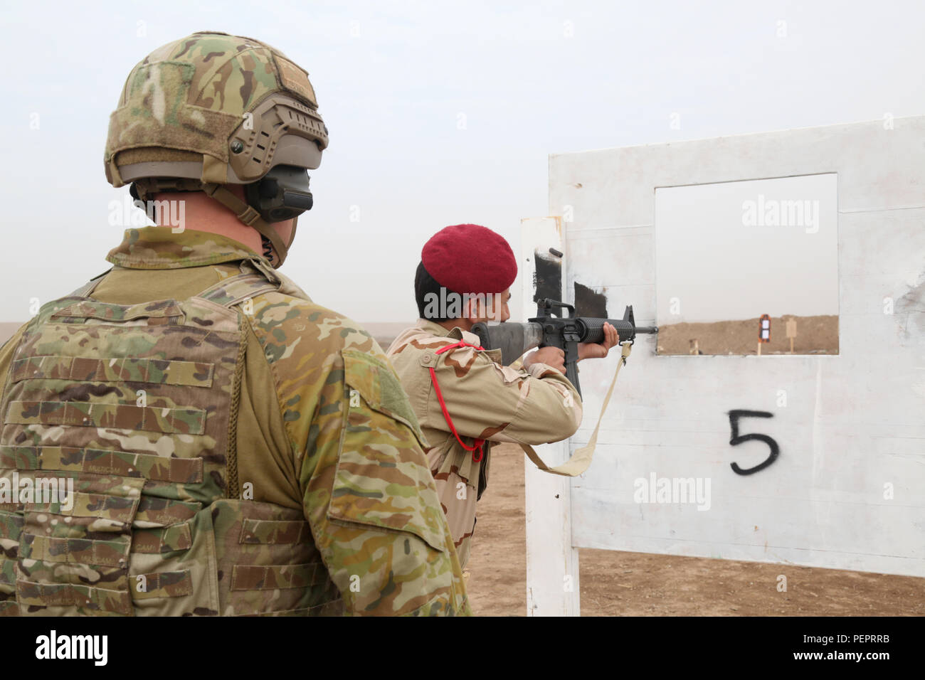 An Australian soldier assigned to, Task Group Taji, assists an Iraqi ...