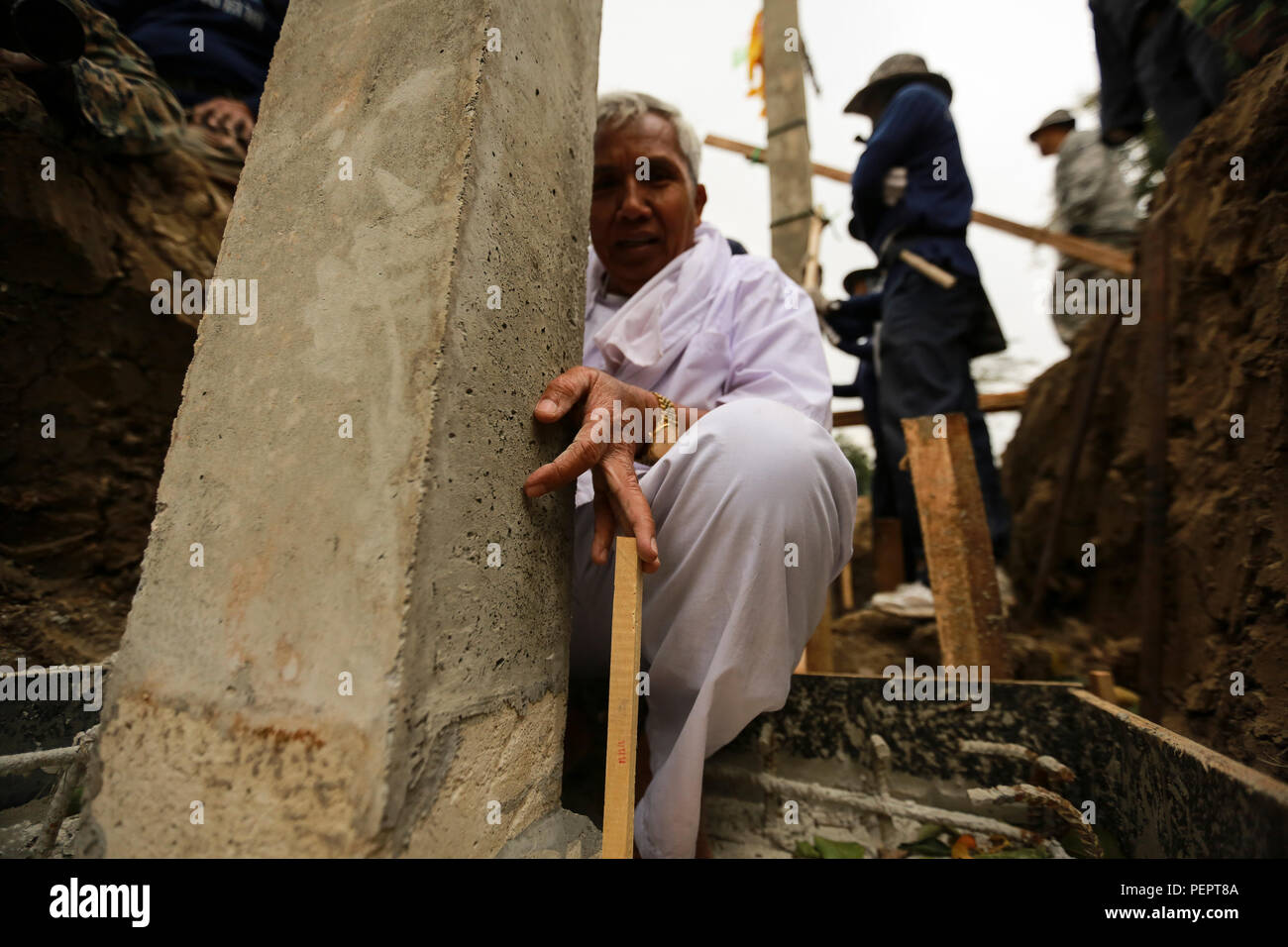 Samai Tanapai Bul plants a wooden stake next to a pillar as part of a ...