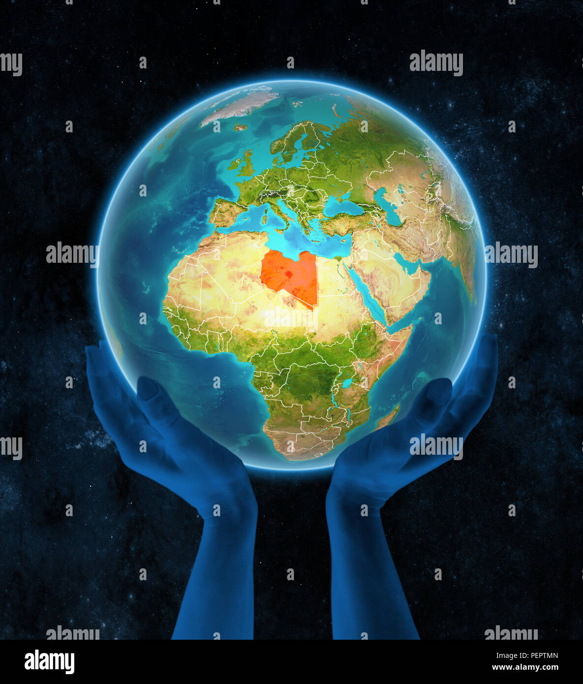 Libya on planet Earth with visible country borders in hands in space ...