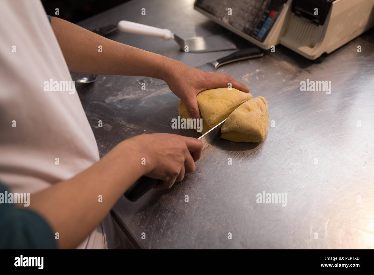 Male baker cutting dough in bakery Stock Photo - Alamy