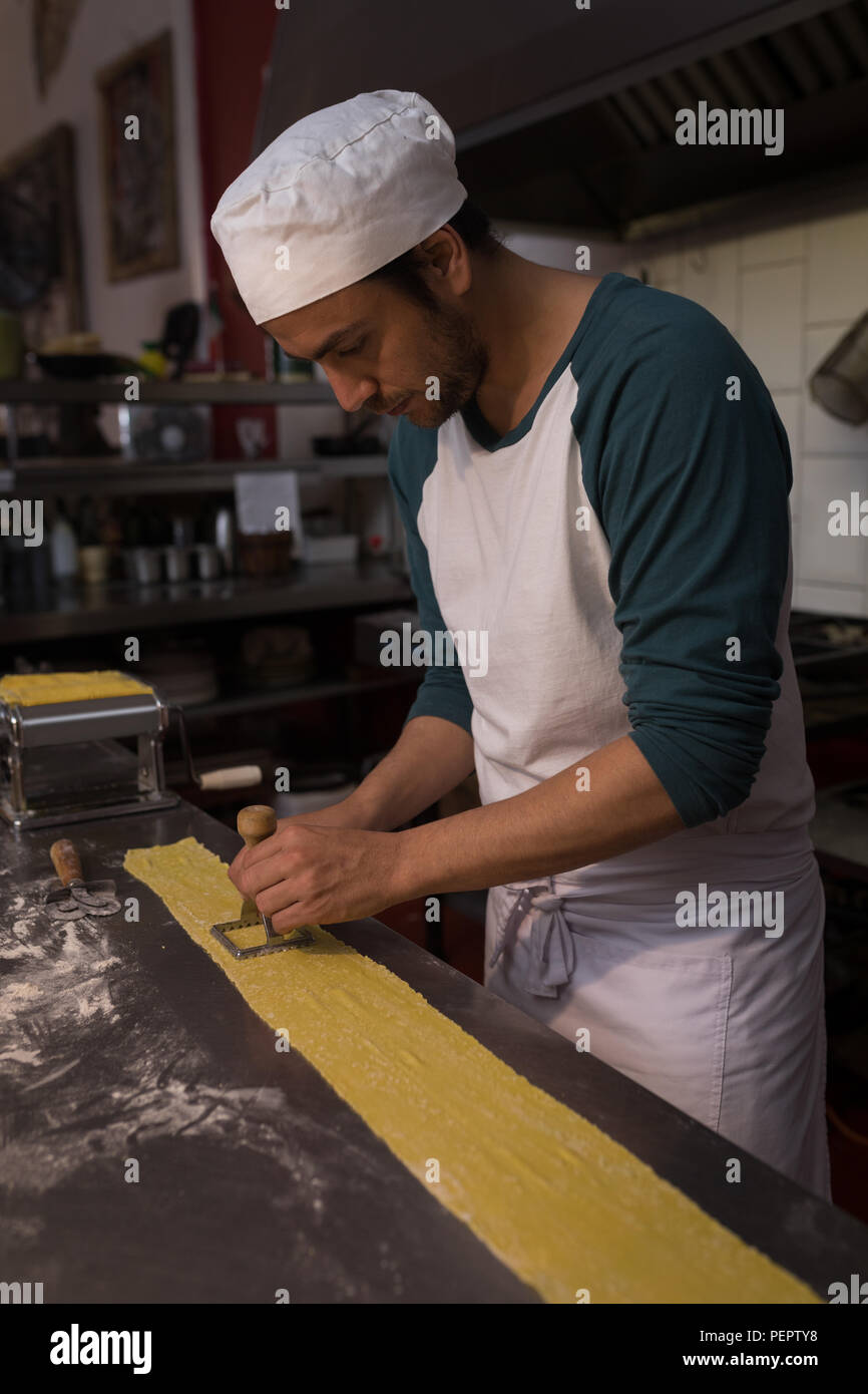 Baker cutting pasta in bakery Stock Photo - Alamy
