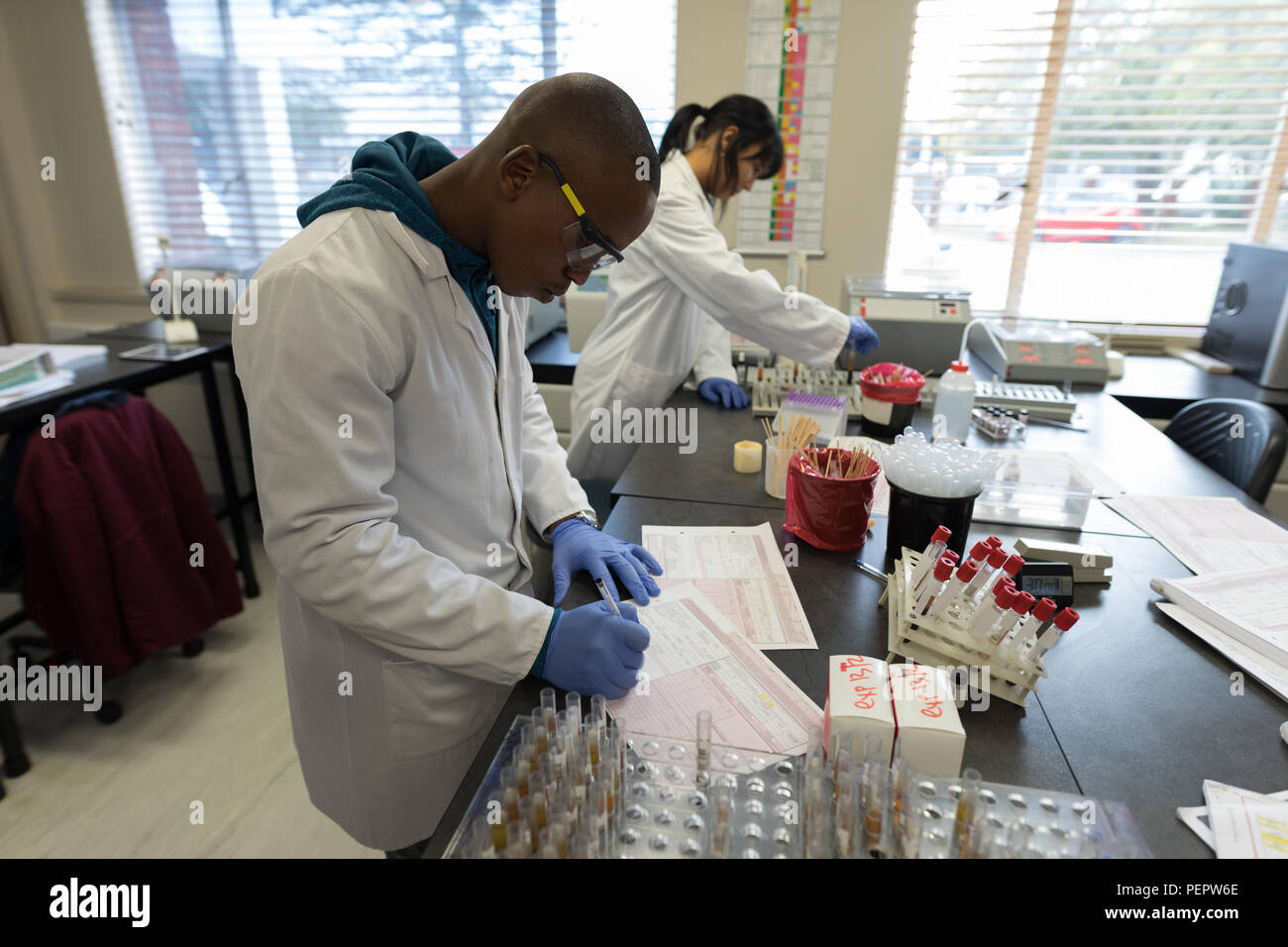 Laboratory technician checking invoices Stock Photo - Alamy