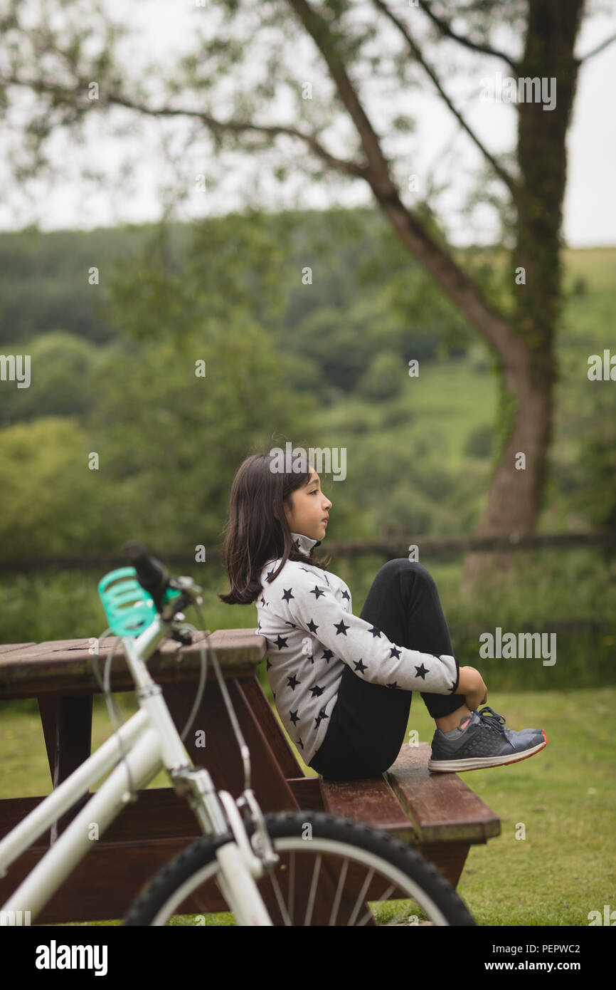 Girl sitting on bench at garden Stock Photo - Alamy